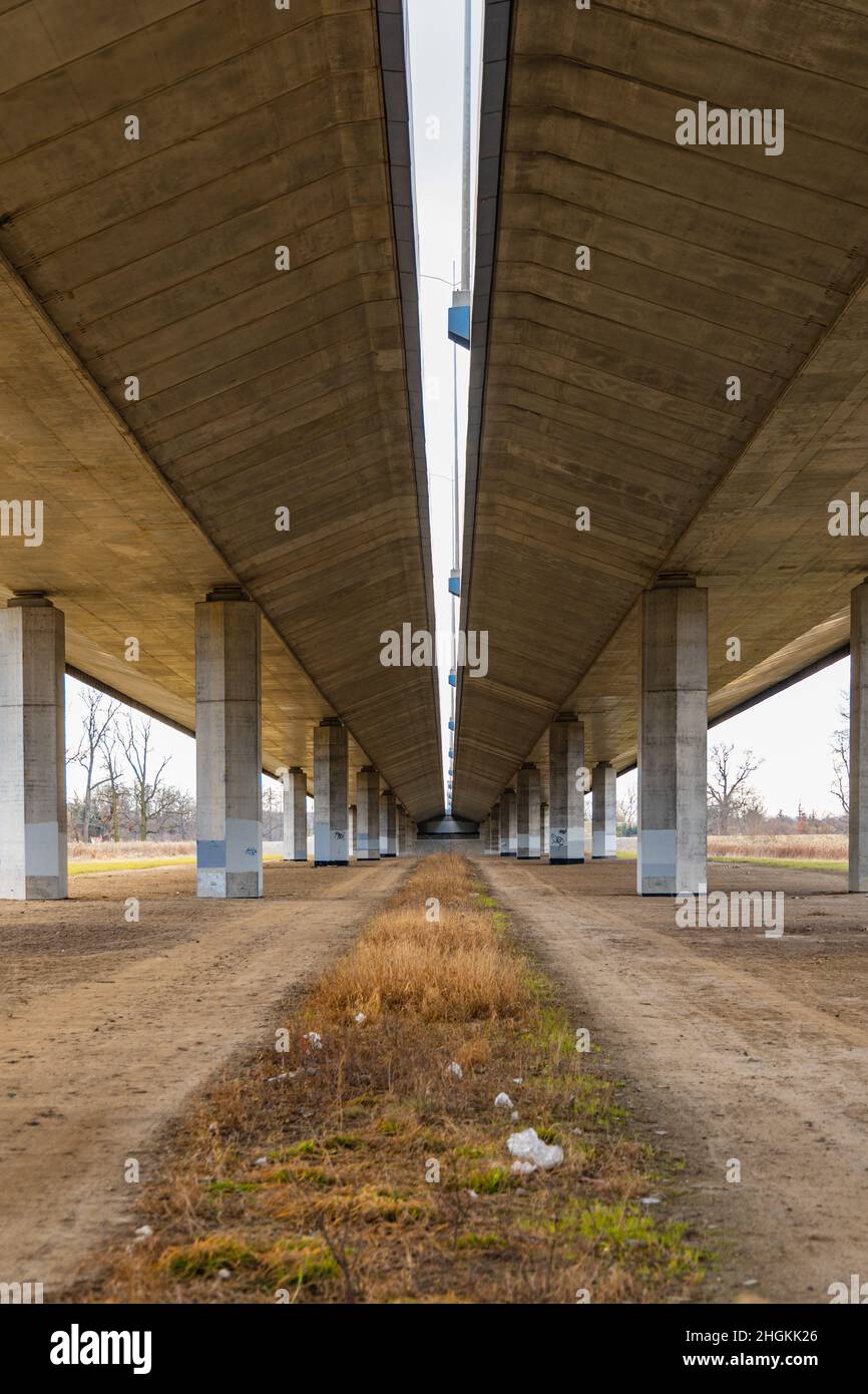 Central view from under of highway bridge with high concrete pillars ...