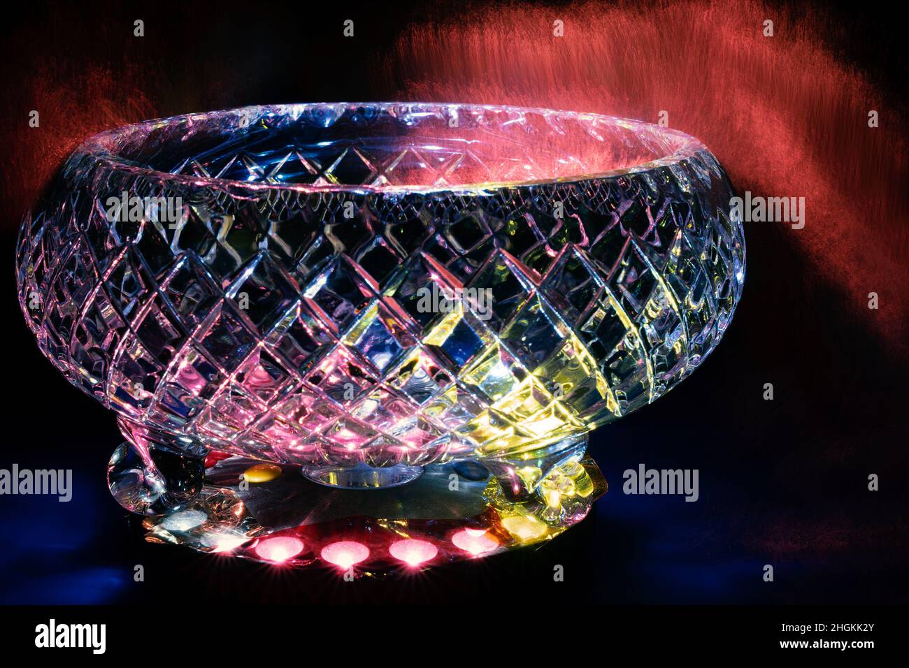 Pink fiber optic lights around a crystal bowl lit with colored lights ...