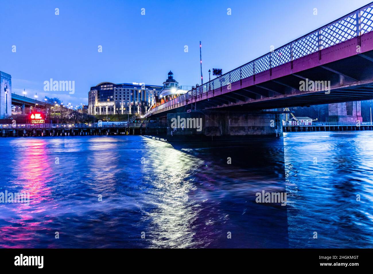 Scenic evening view of newcastle cityscape with swing bridge over calm ...