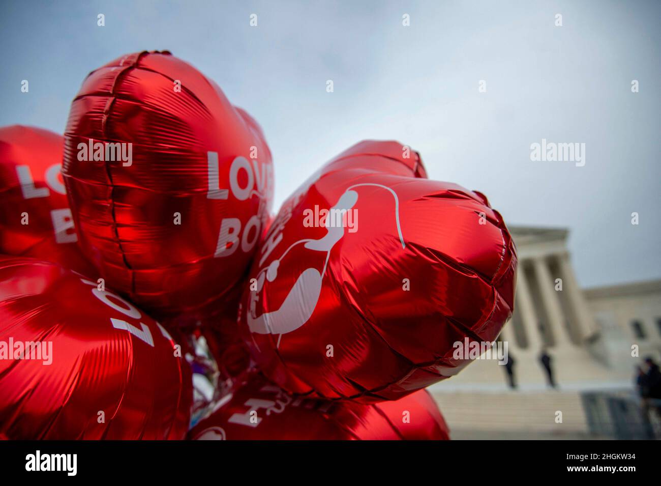 Red heart balloons displaying â Love Them Bothâ and a mother holding ...