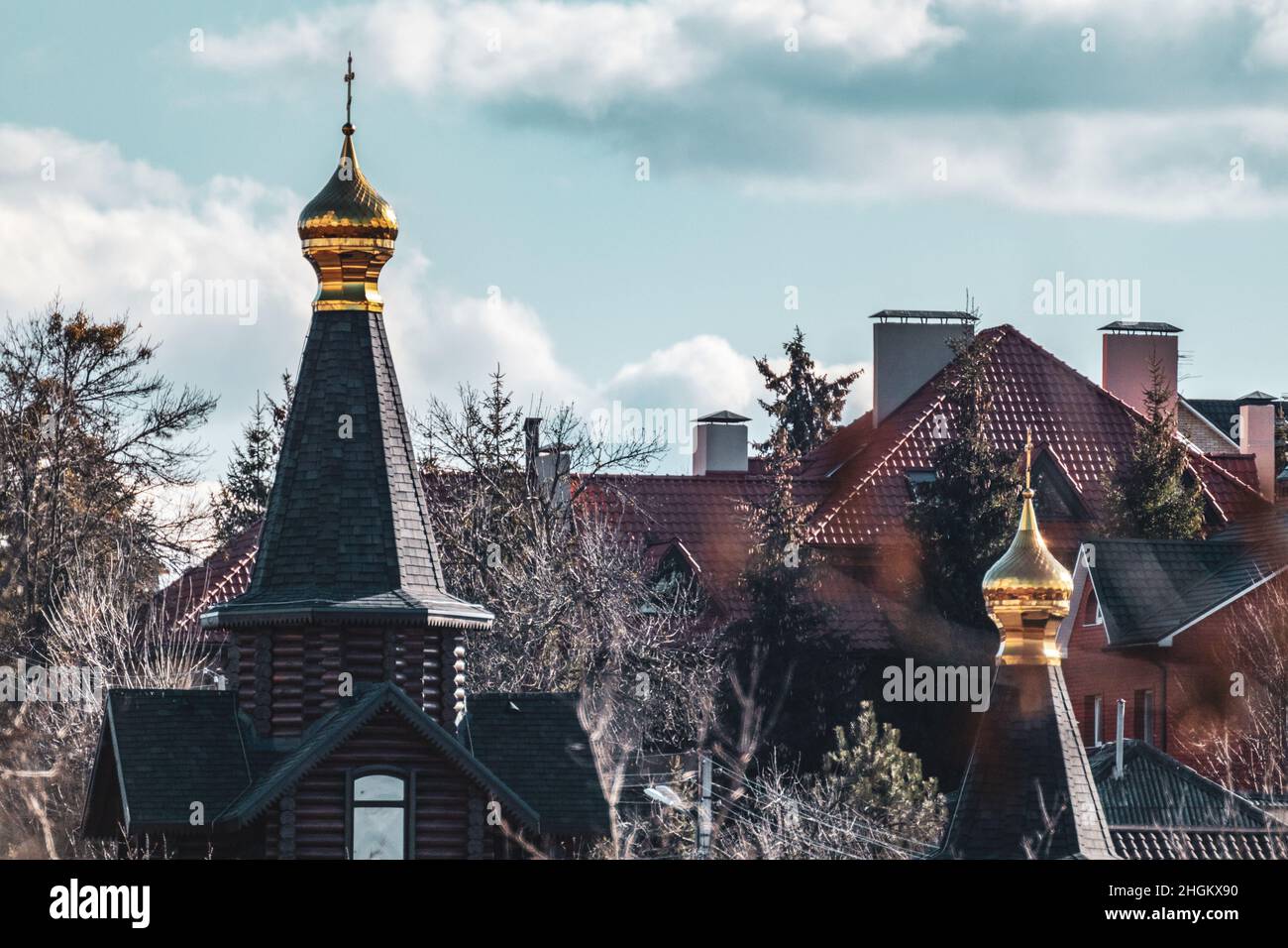 Gold dome with cross on wooden church top close view on scenic blue sky ...