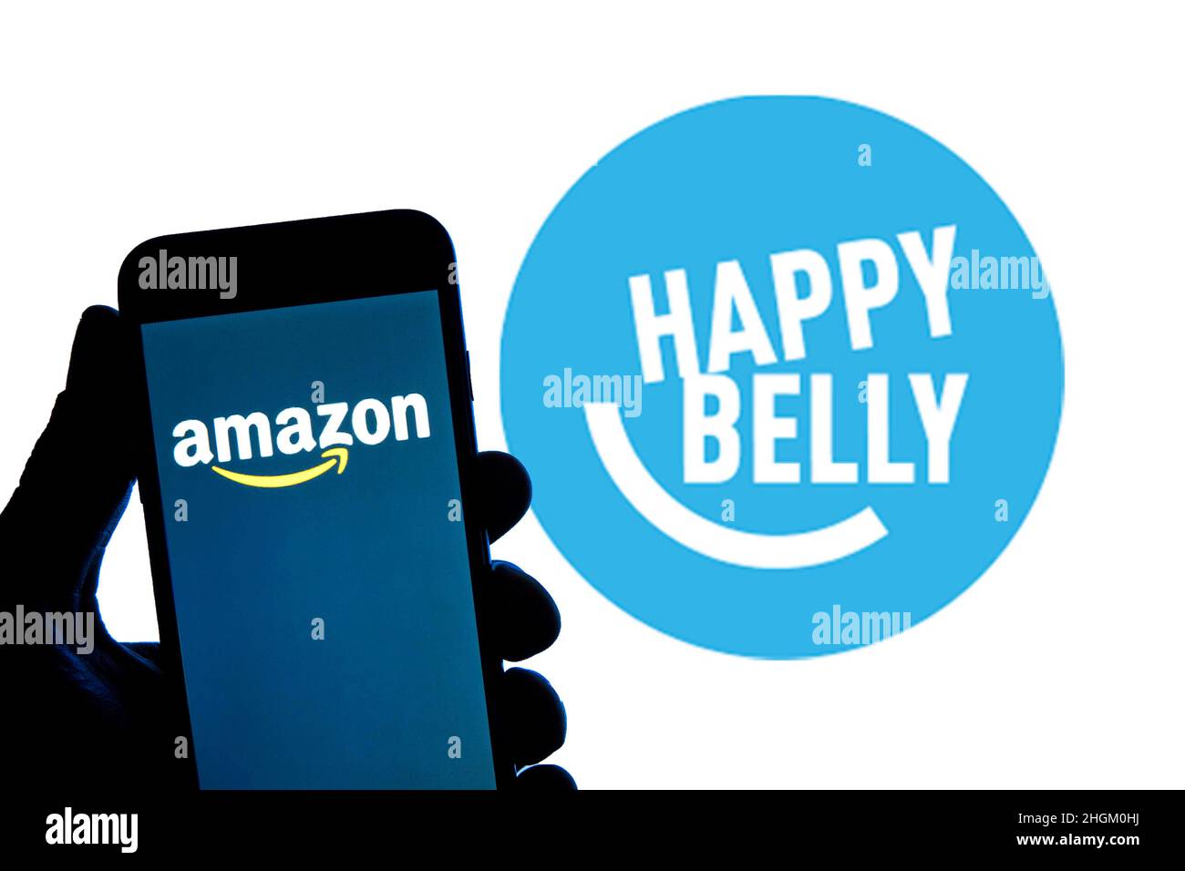In this photo illustration an Amazon logo seen displayed on a smartphone with a Happy Belly logo ...