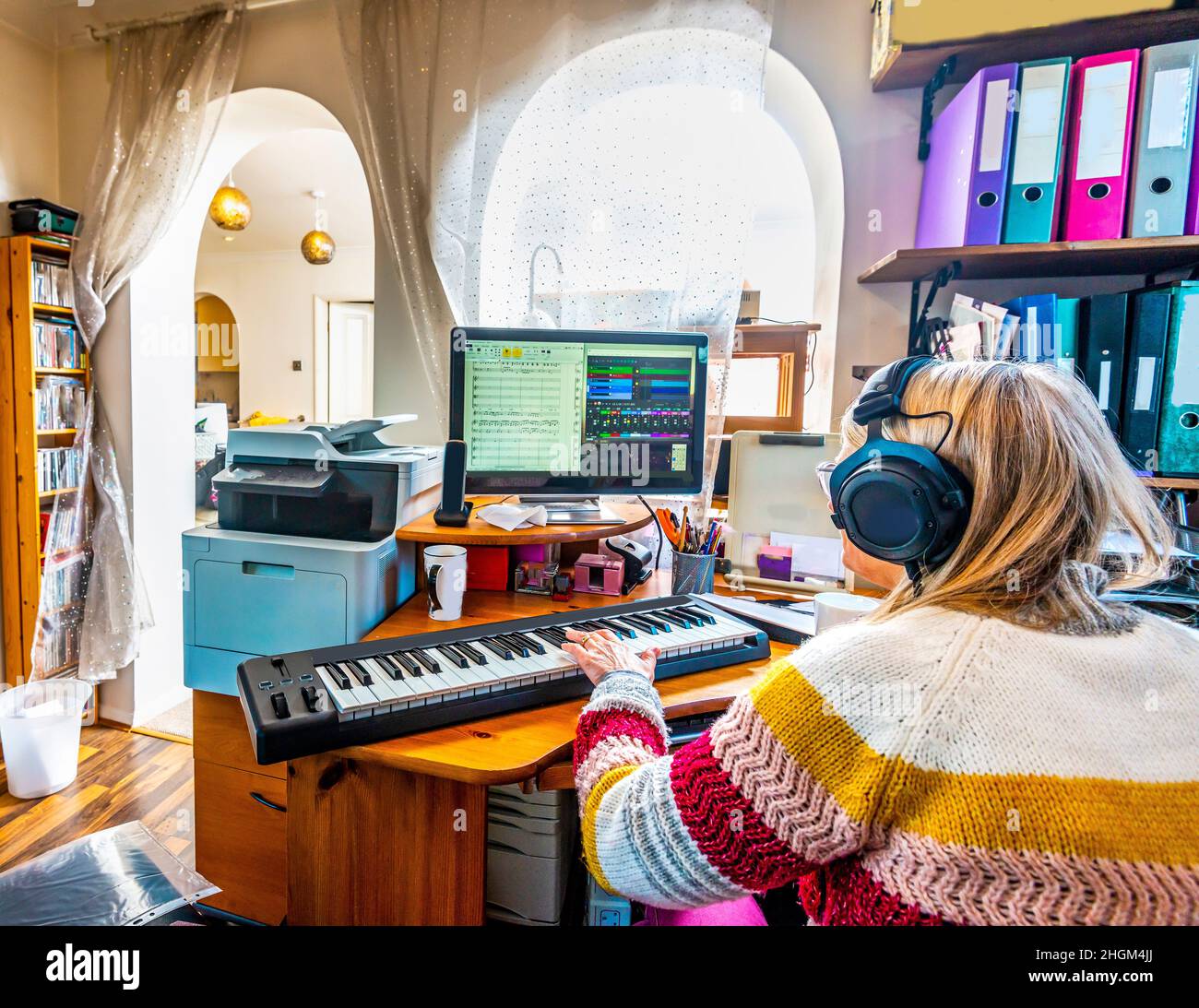 Woman inside her house,writing,arranging and recording music on her ...