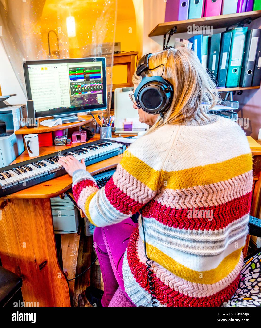 Woman inside her house,writing,arranging and recording music on her ...