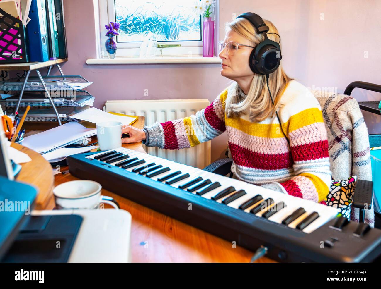 Woman inside her house,writing,arranging and recording music on her ...