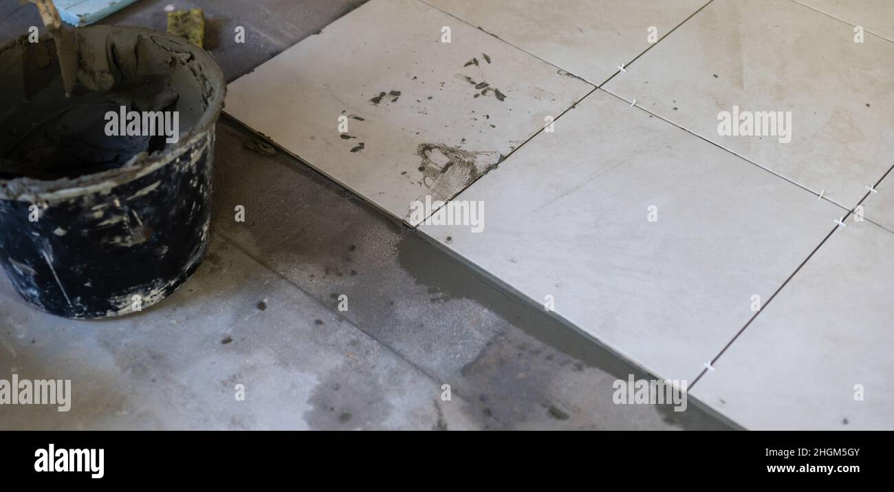 Close-up Installing tiles floor in construction work Stock Photo - Alamy