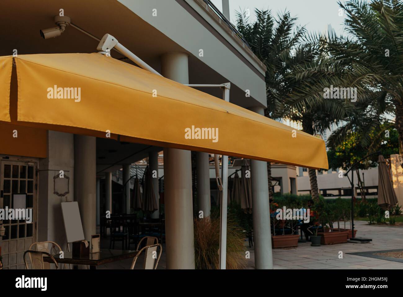 Cozy empty terrace of the outdoor cafe restaurant with wooden table ...