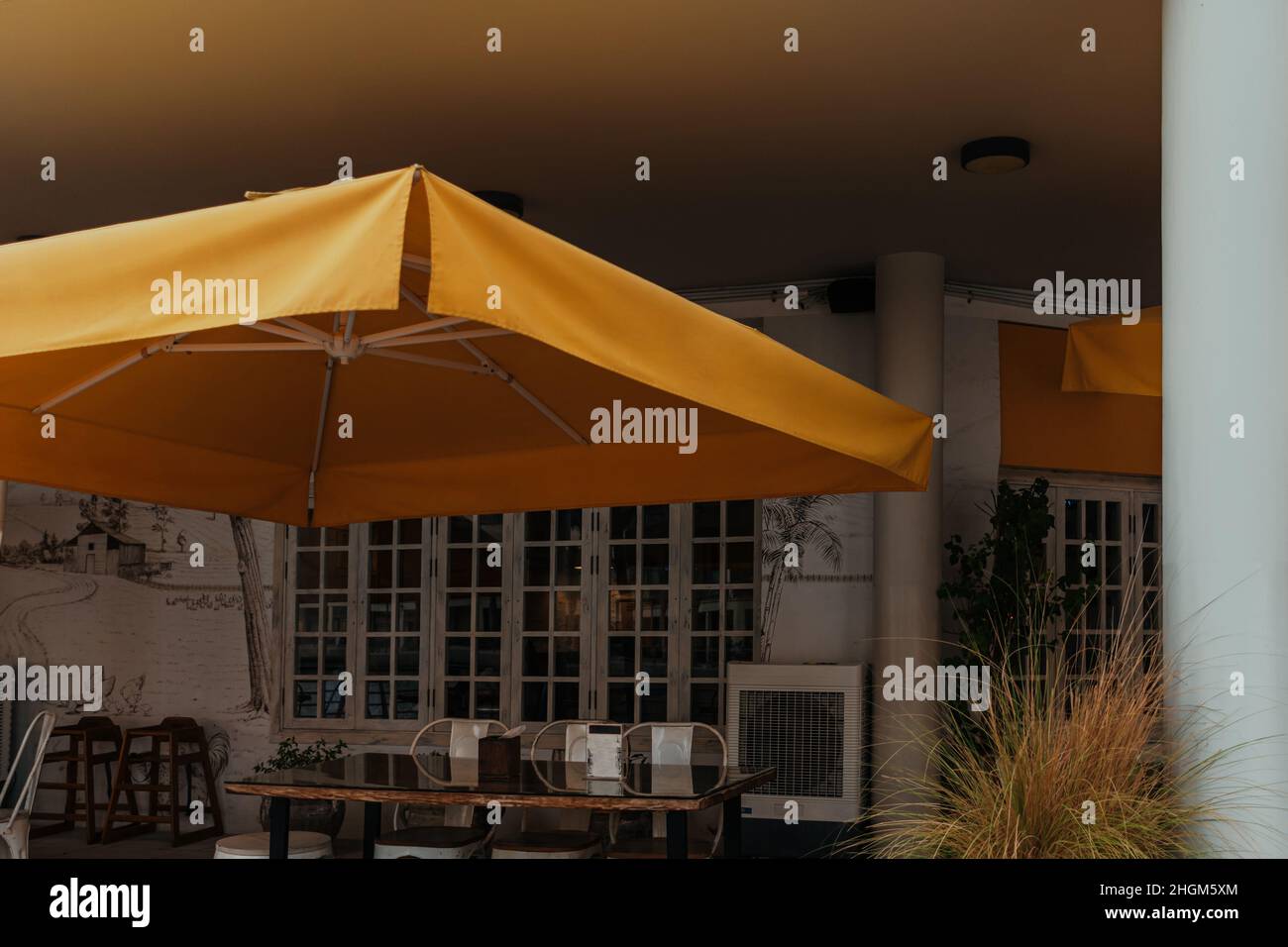 Cozy empty terrace of the outdoor cafe restaurant with wooden table ...