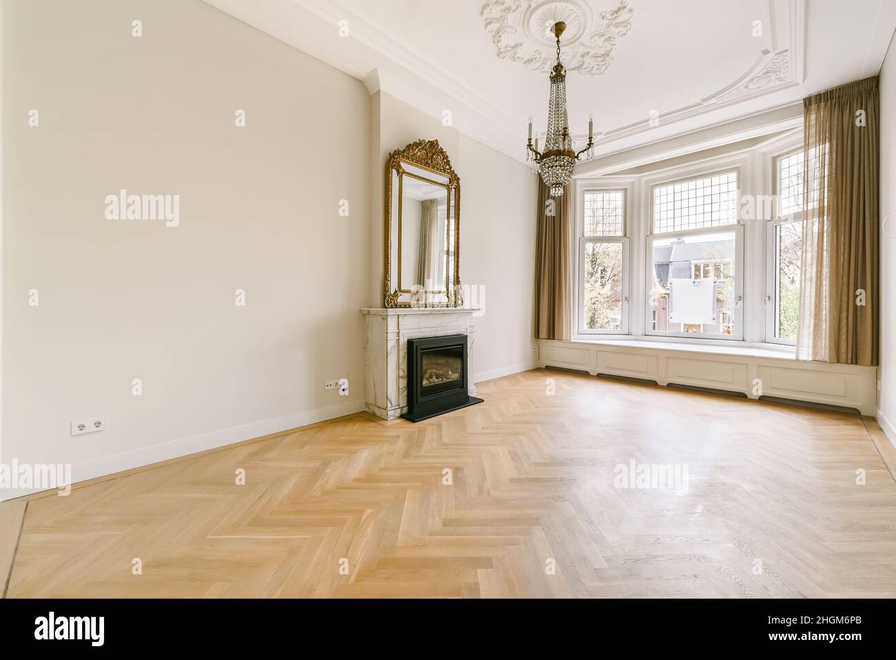 Amazing design of an empty room with a black fireplace and chandelier ...