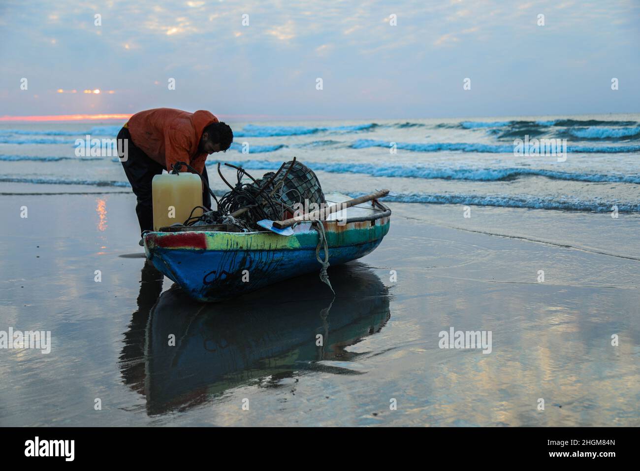 Palestinian fisherman prepares himself to sail his fishing boat into ...