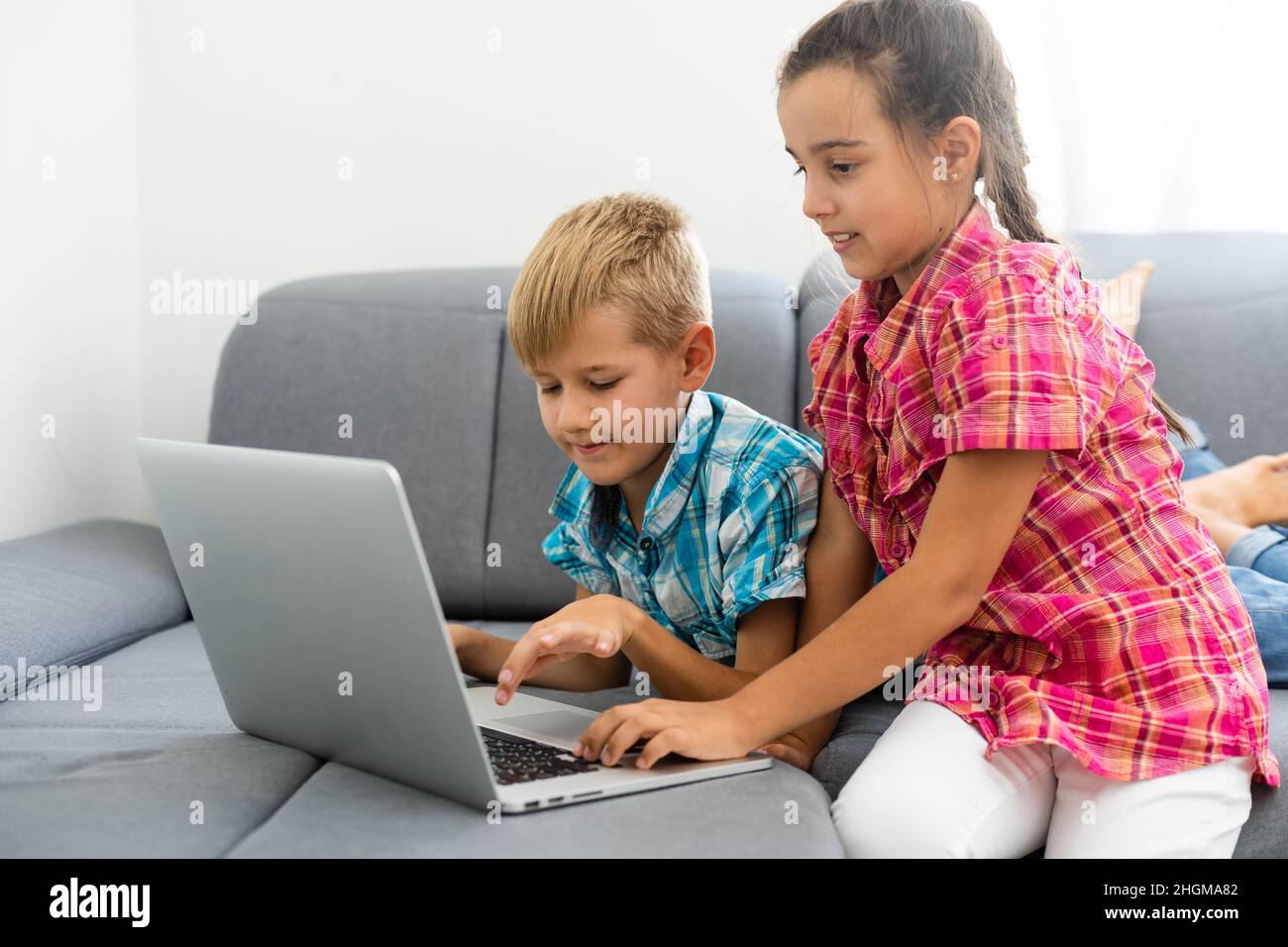 Kids playing with laptop computer at home Stock Photo - Alamy