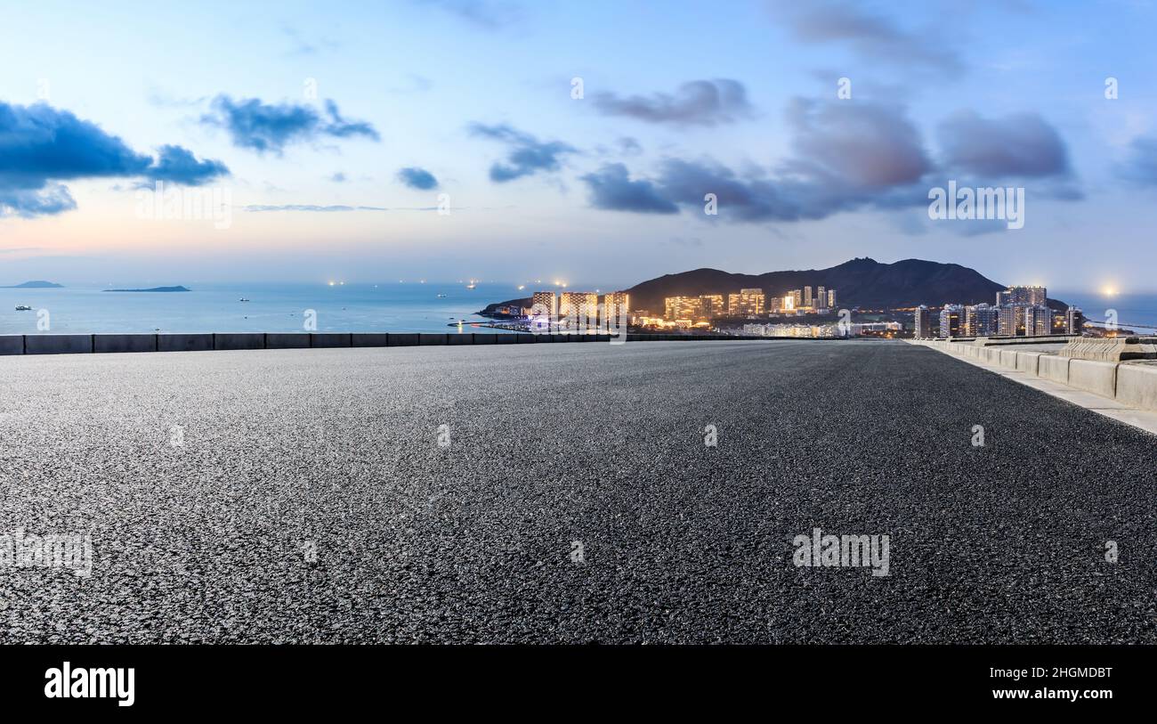 Asphalt road and modern city skyline with buildings at sunset Stock ...