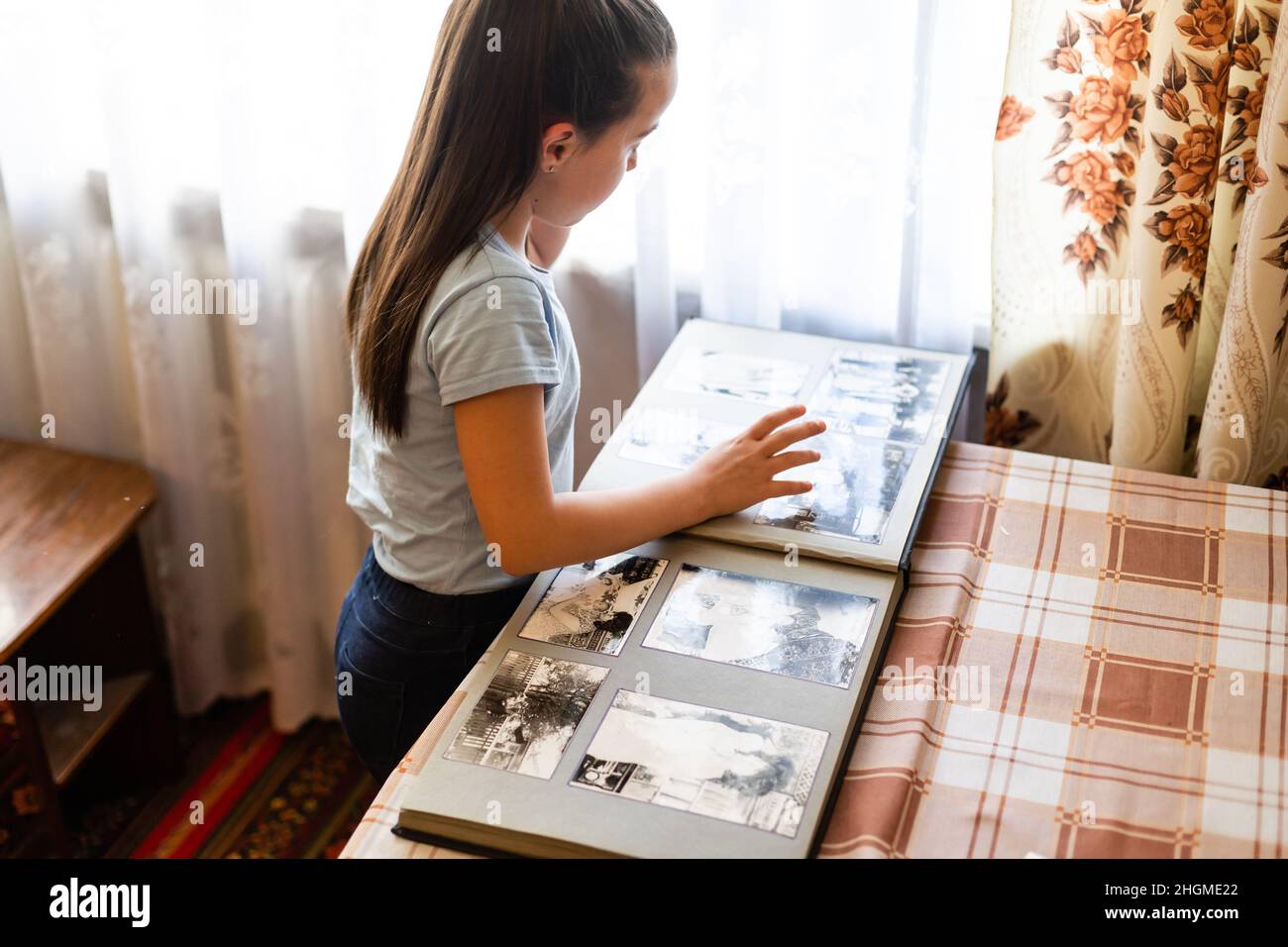 Adorable girl browsing an family album. Vintage style Stock Photo - Alamy