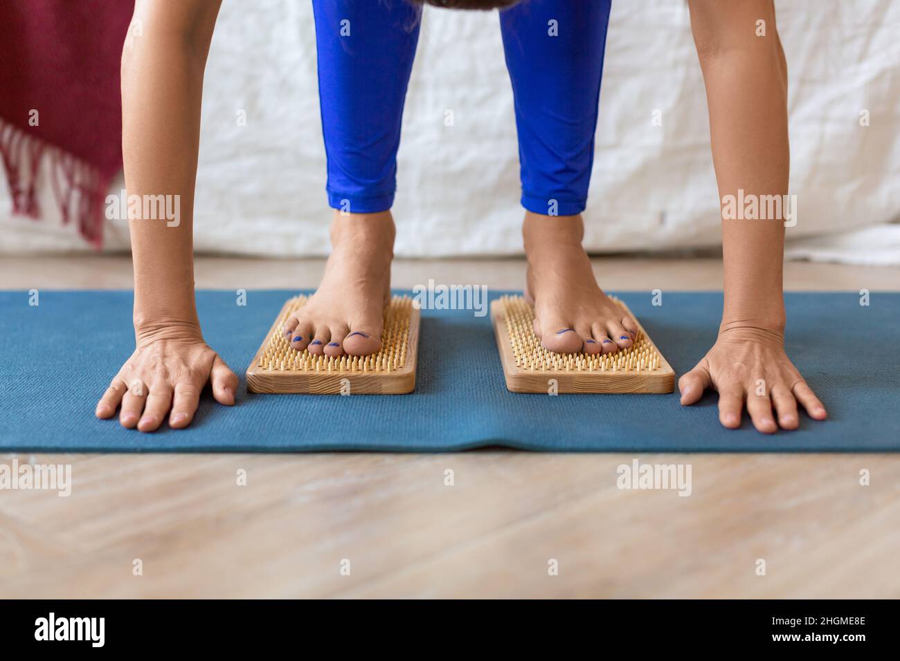 Woman standing on a board with sharp nails - feet and legs close-up ...