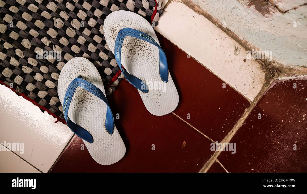 a pair of flip flops on the house mat Stock Photo - Alamy