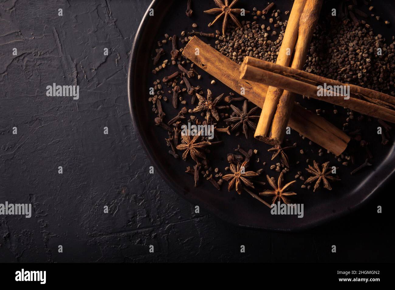 Selection of various spices on textured black background. cardamom ...