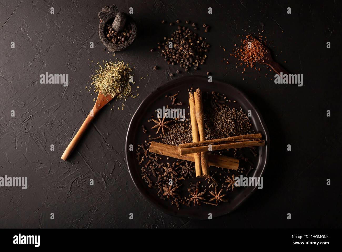 Selection of various spices on textured black background. Pepper ...