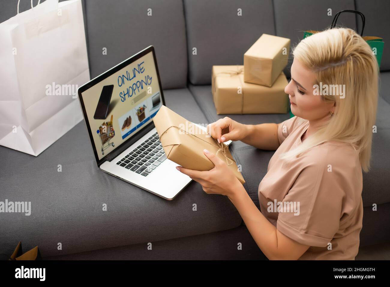 Young woman with laptop and shopping bags at home. Black Friday sale ...