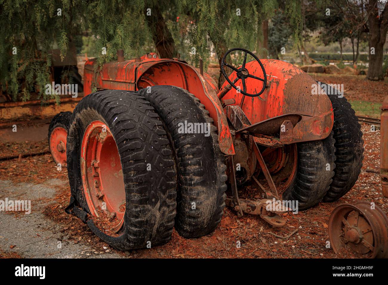 Old and rusty abandoned heavy equipment, a tractor amongst trees with ...