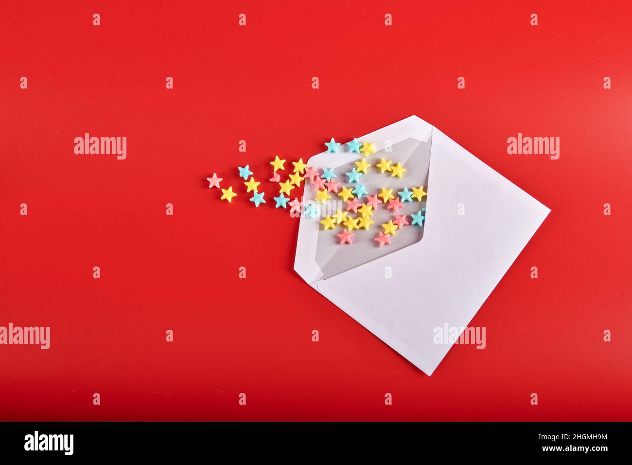 white envelope with colored stars on a red background Stock Photo - Alamy