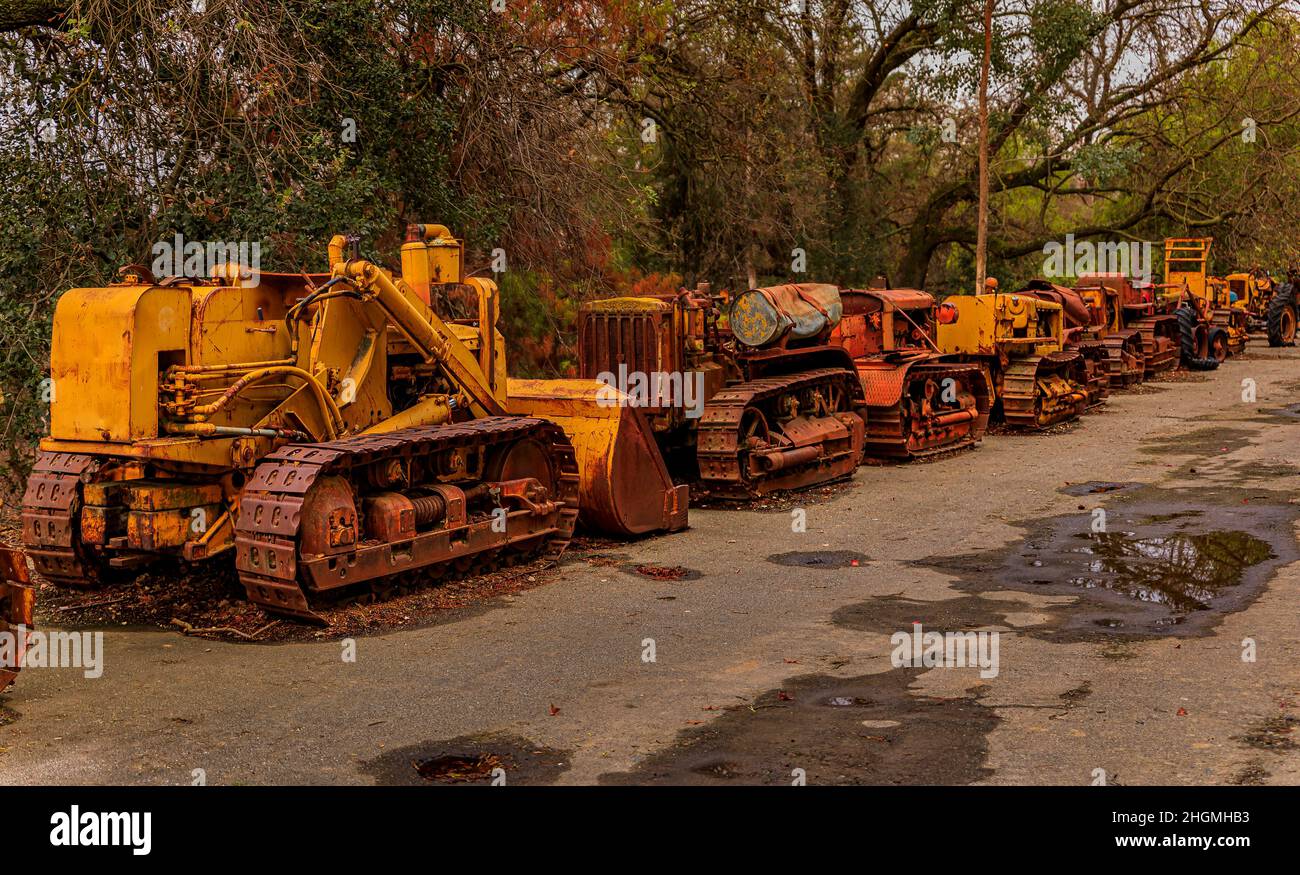 Old and rusty abandoned heavy equipment, tractors, excavators and ...