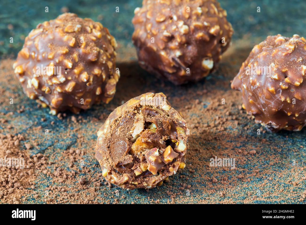 Group of chocolate sweet candy, bonbons on stone texture with cocoa ...