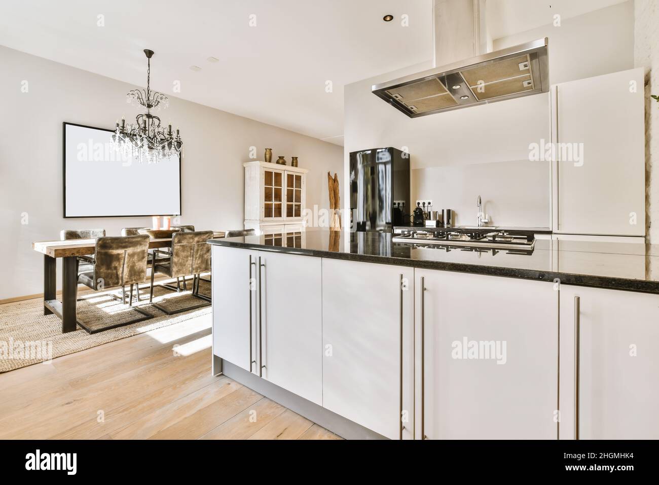 Comfortable kitchen with white kitchen unit and black marble countertop ...