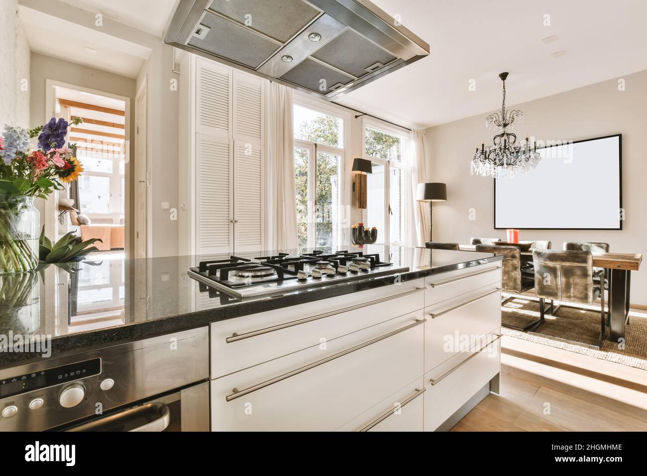 Comfortable kitchen with white kitchen unit and black marble countertop ...