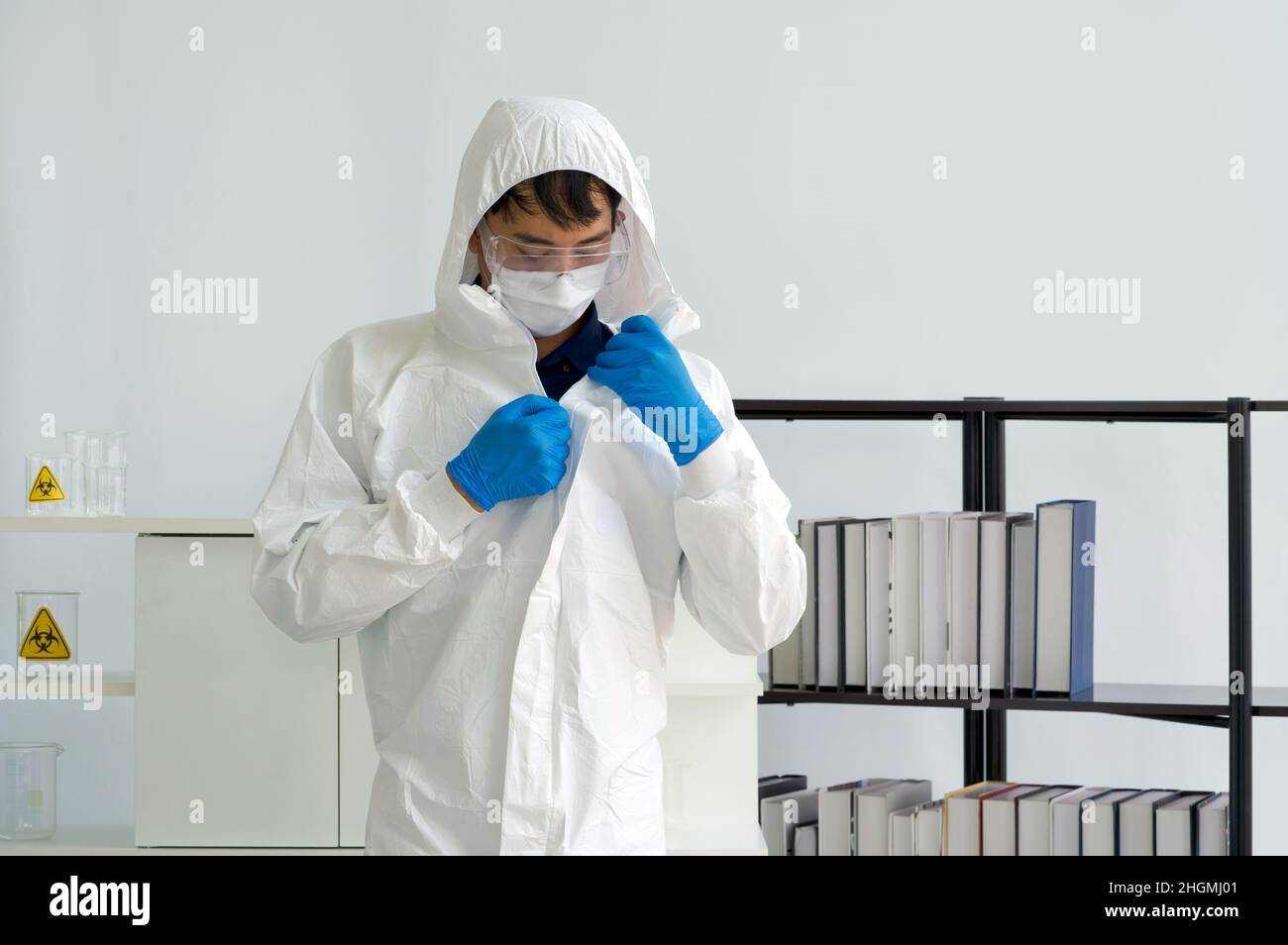Asian scientist with face mask wearing virus protective clothing before ...