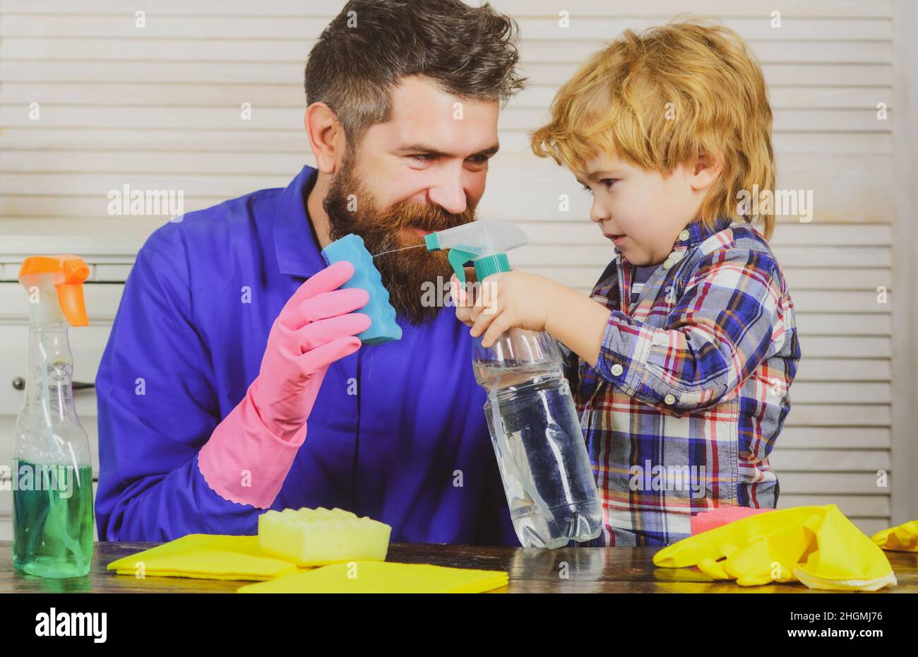 Dad and son with cleaning supplies. Father has fun with child and clean ...