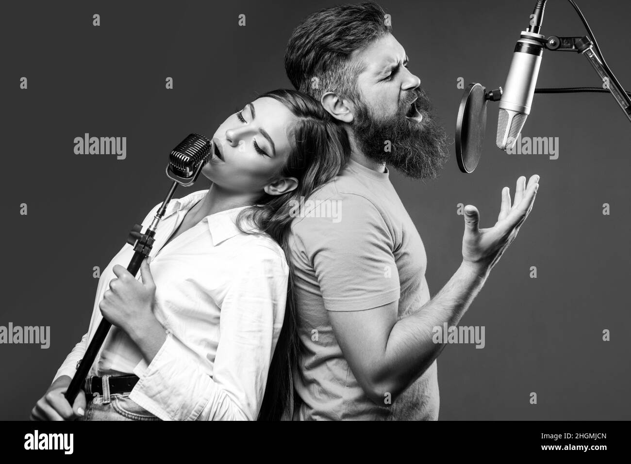 Couple duet with microphone singing song. Musician in music hall Stock ...