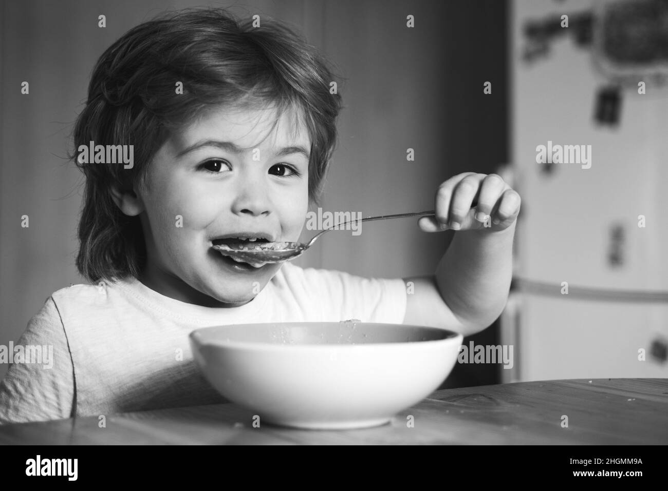 The child in the kitchen at the table eating. Kid eating. Happy child ...