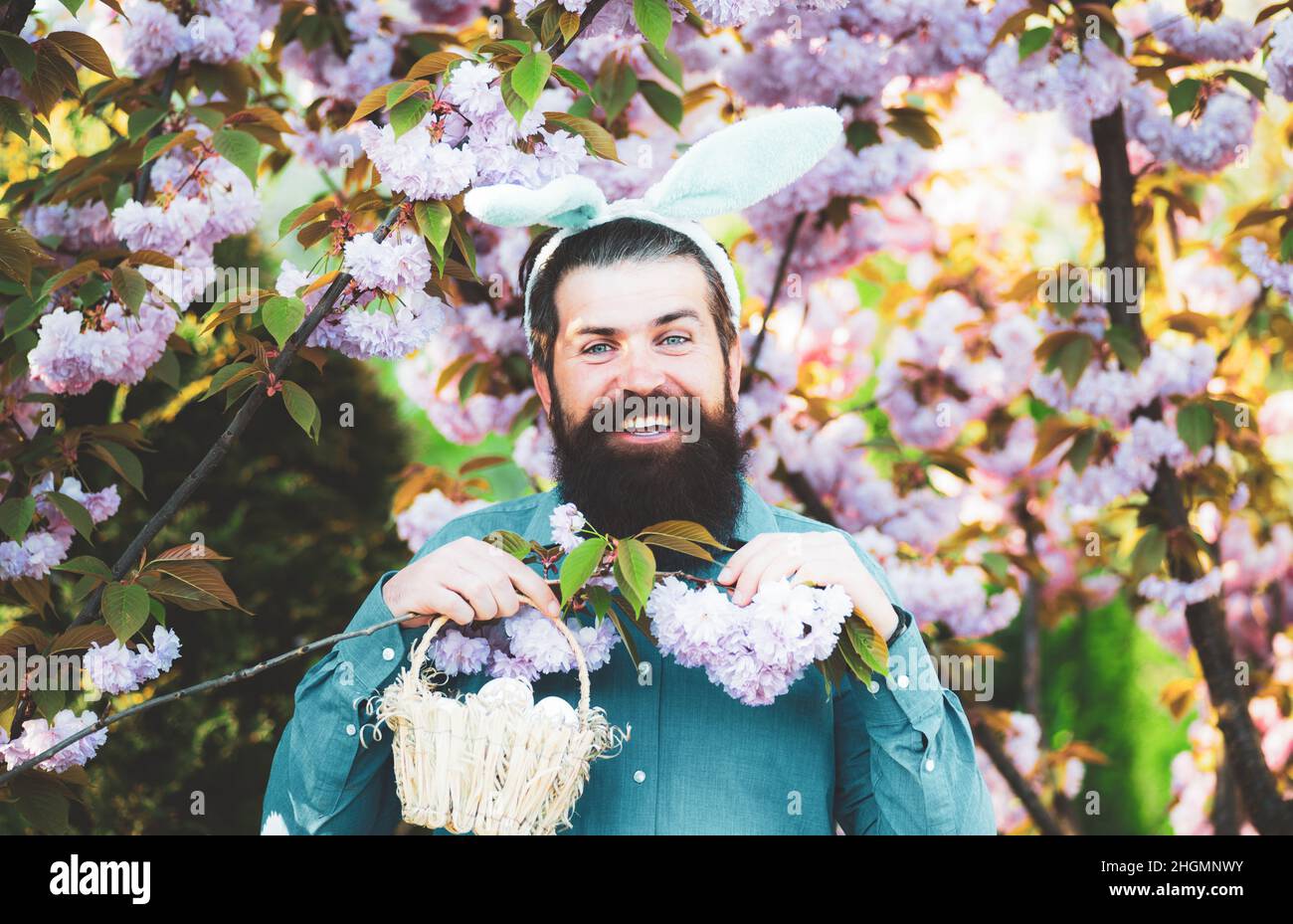 Man in bunny ears holds Easter egg. Rabbit man. Man with rabbit ears ...
