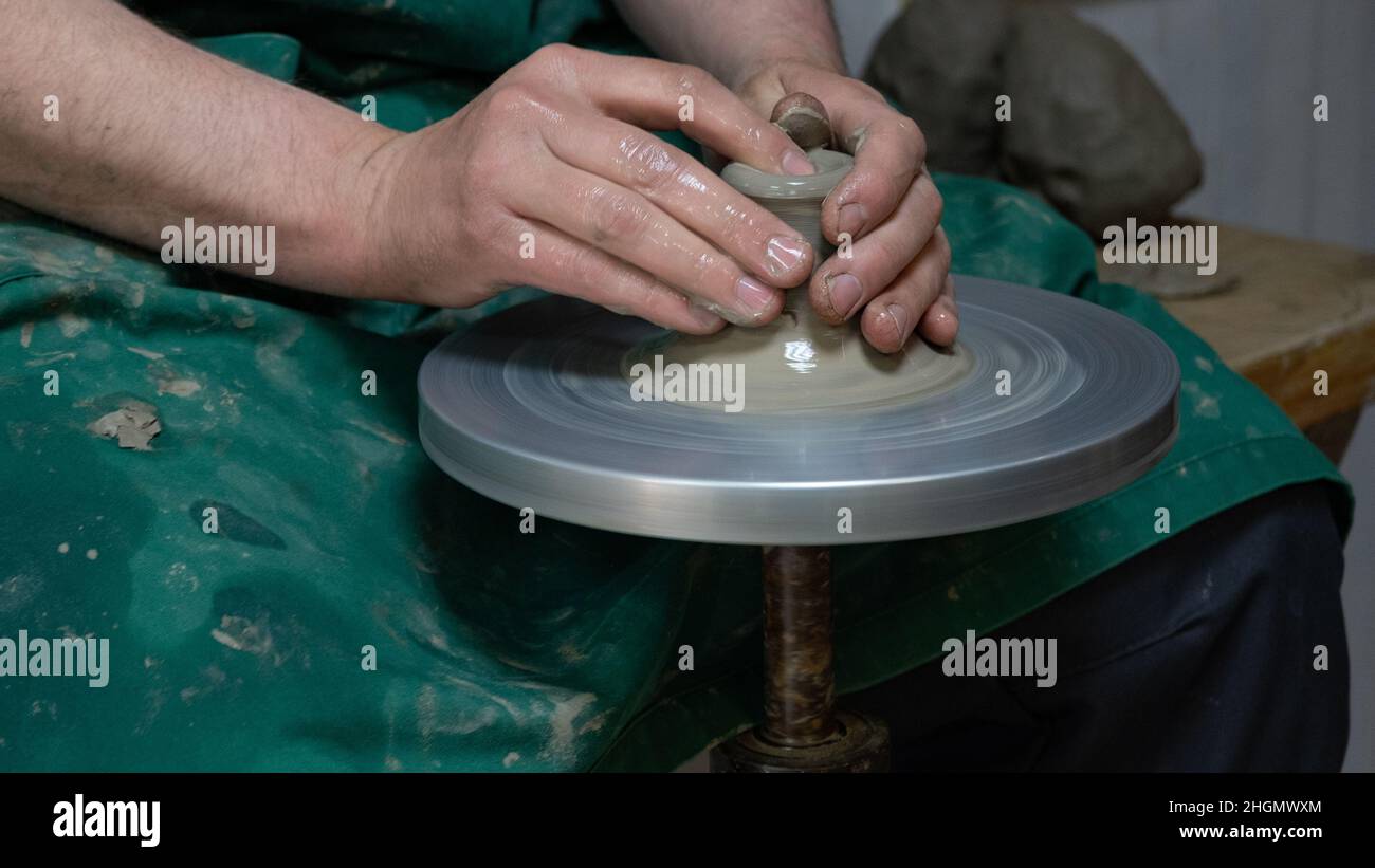 Craft hands making a clay pot. Men's hands. Potter at work. Creating ...