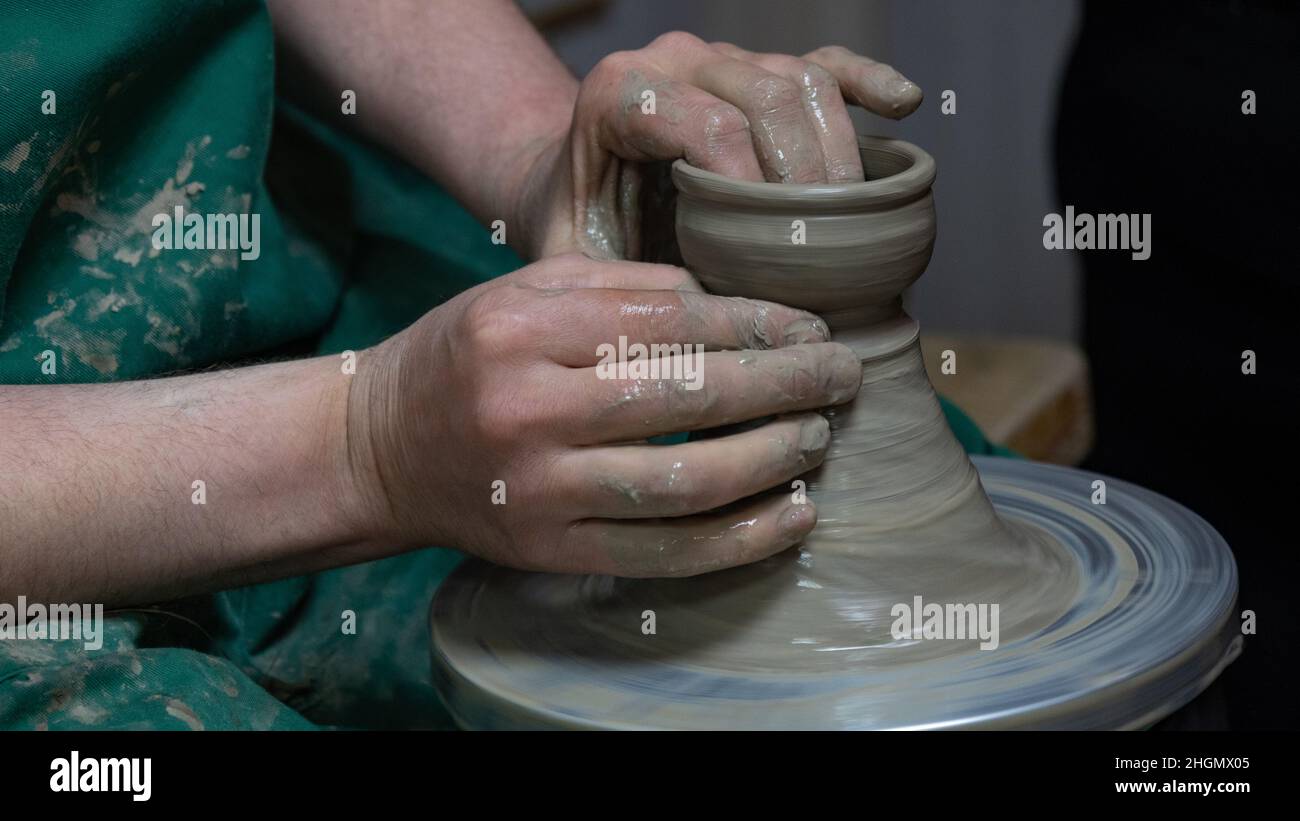 Craft hands making a clay pot. Men's hands. Potter at work. Creating ...