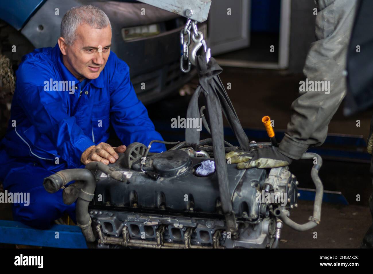 Photo of diesel engine. An experienced mechanic and his colleague ...