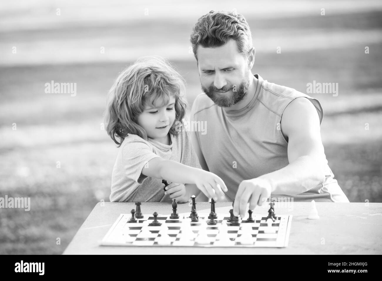 Father and son playing chess spending time together outdoor. Kid play ...