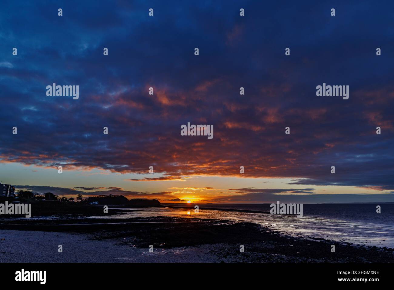 The setting sun lighting up the cloud cover Stock Photo - Alamy