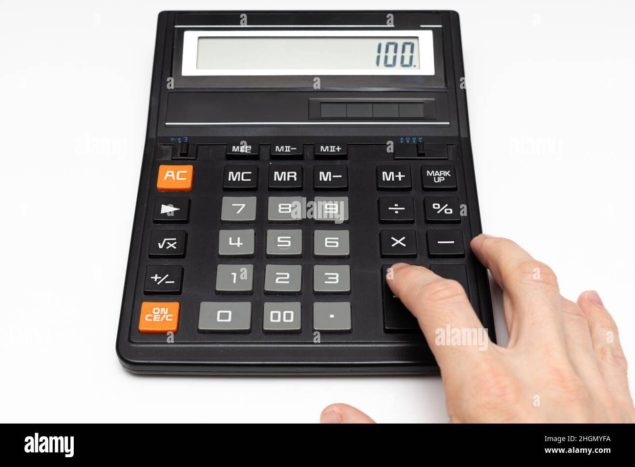 the finger of the hand presses the keys of the old calculator. High ...