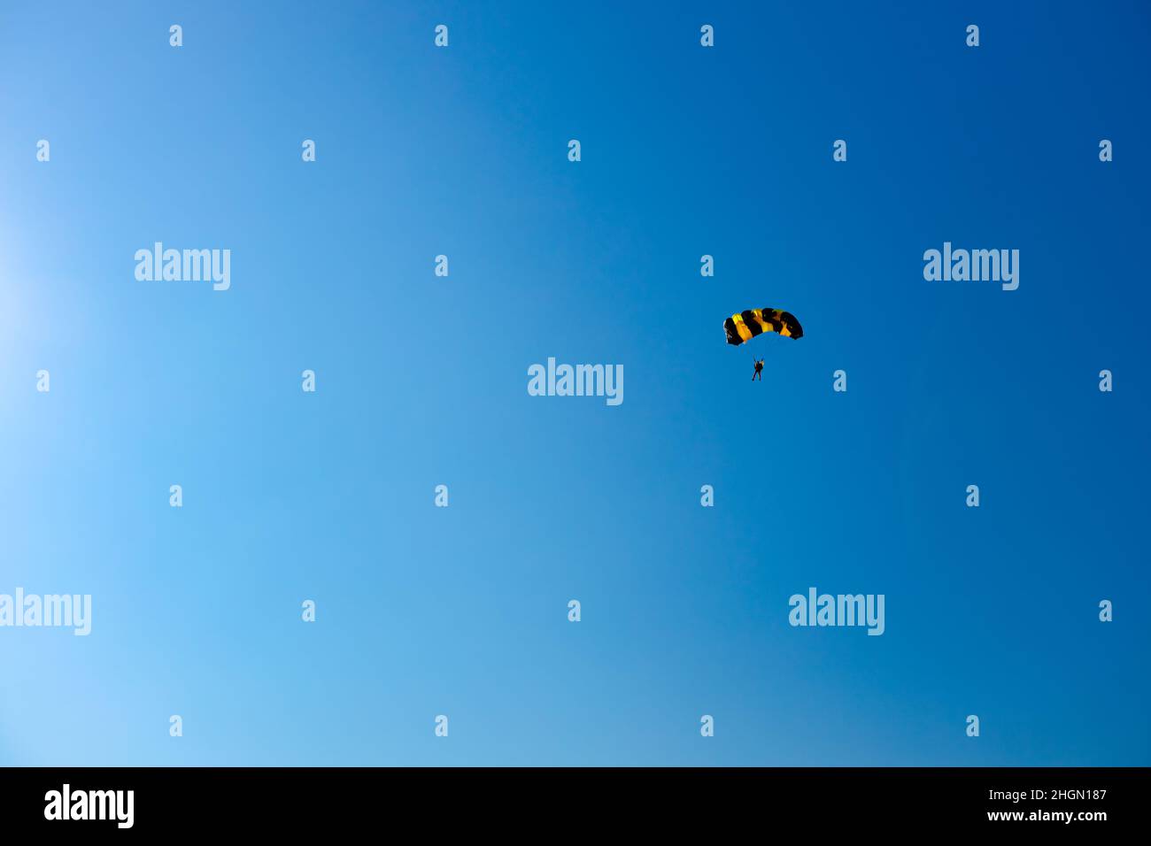 Parachutist is flying slowly down with an open parachute. Skydiving ...