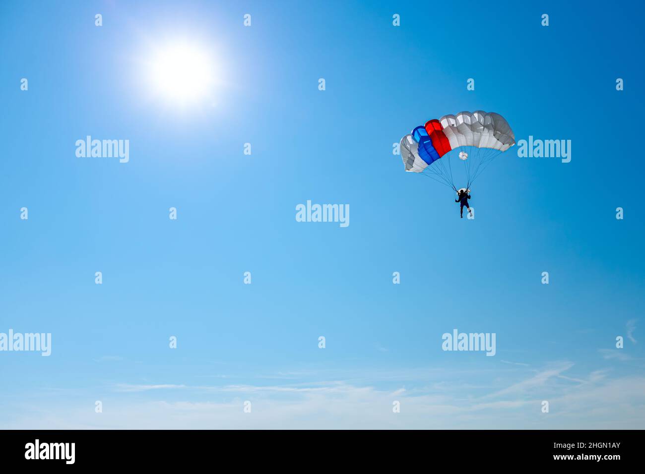 Parachutist is flying slowly down with an open parachute. Skydiving ...