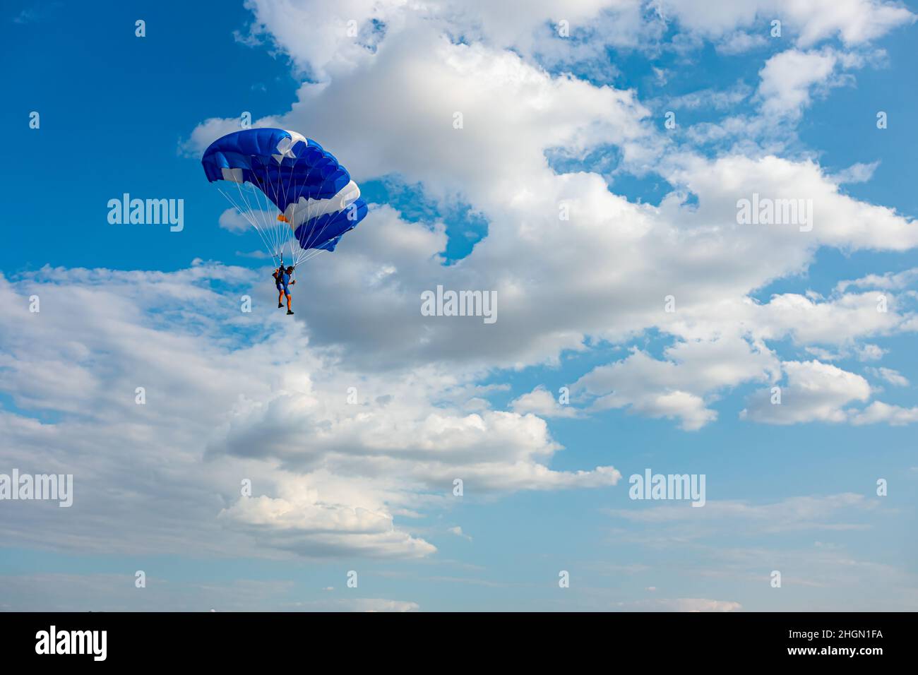 Parachutist is flying slowly down with an open parachute. Skydiving ...