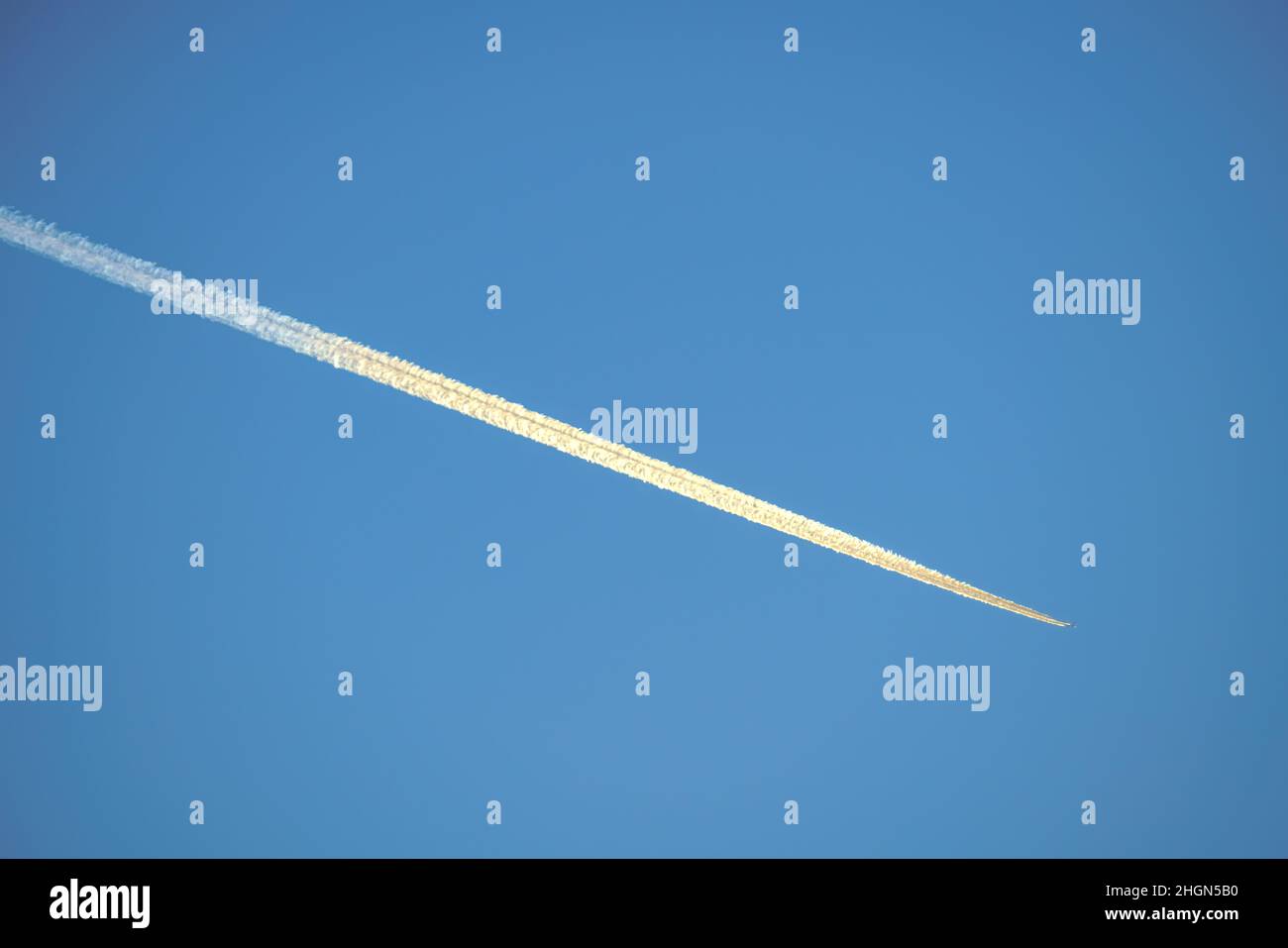 high altitude contrails from a twin engine jet aircraft in a clear blue ...