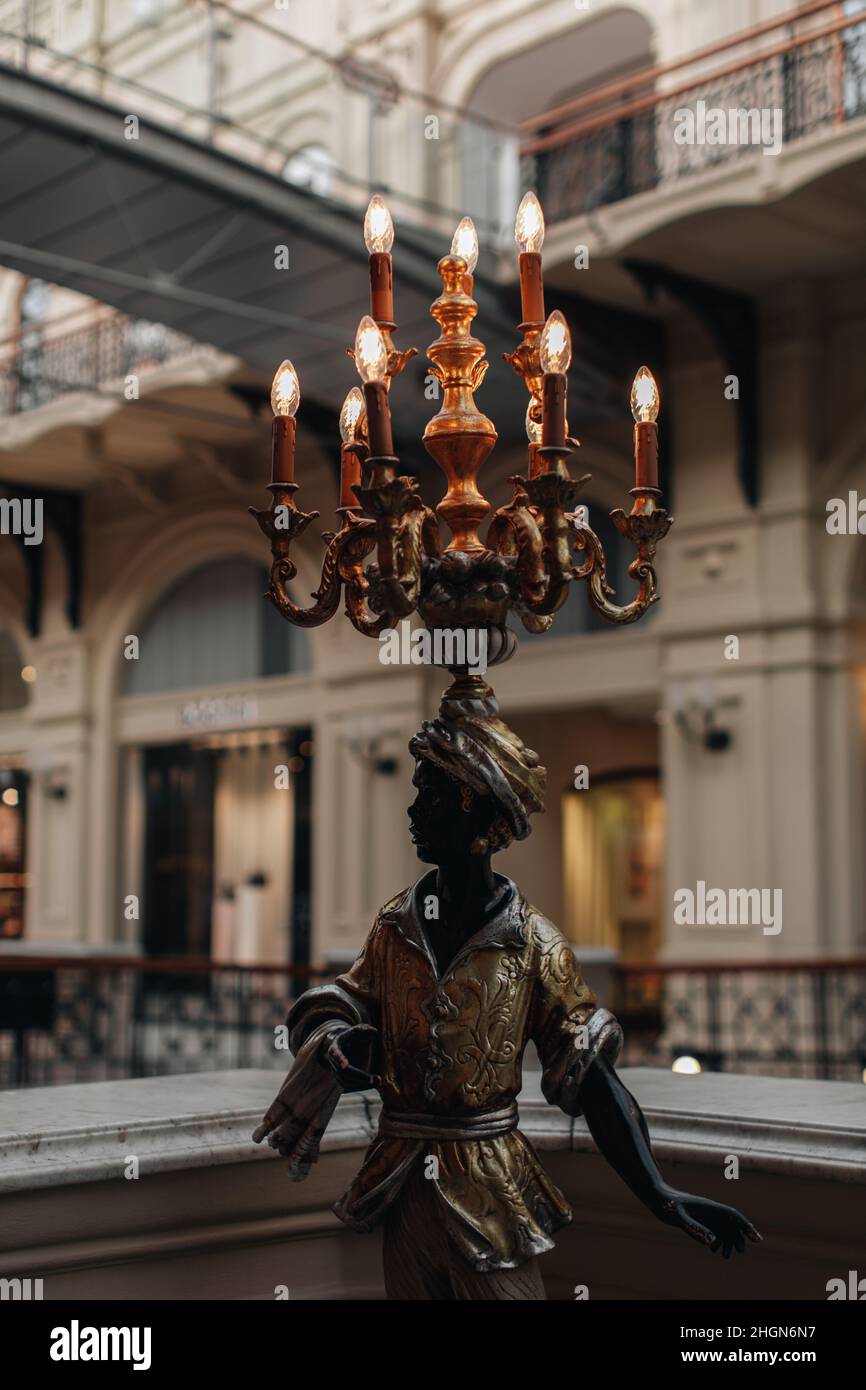 Vintage metal bronze statue of a man with a lamp burning candles in a ...