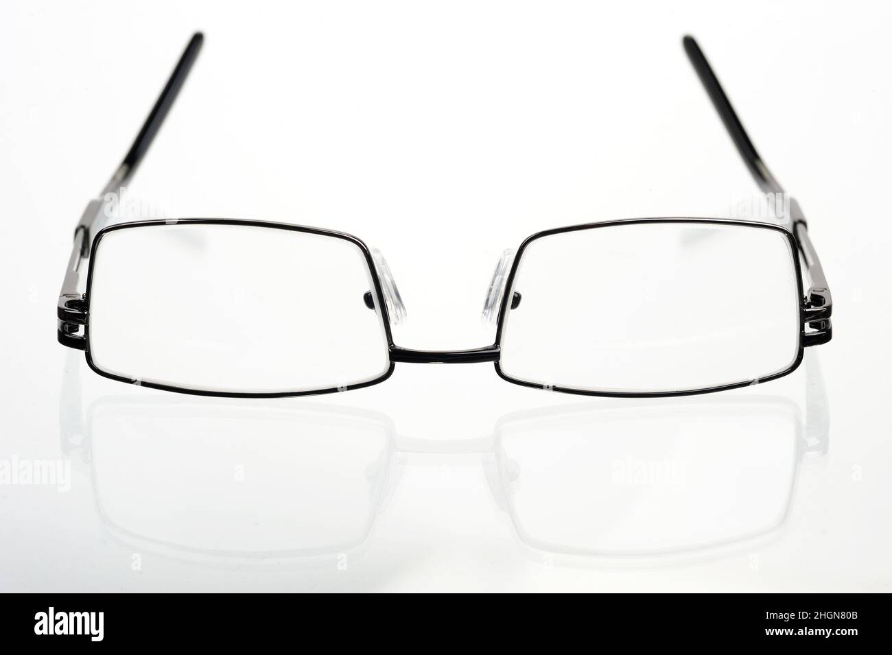 Eyeglasses lying on the glass surface and their reflections Stock Photo ...
