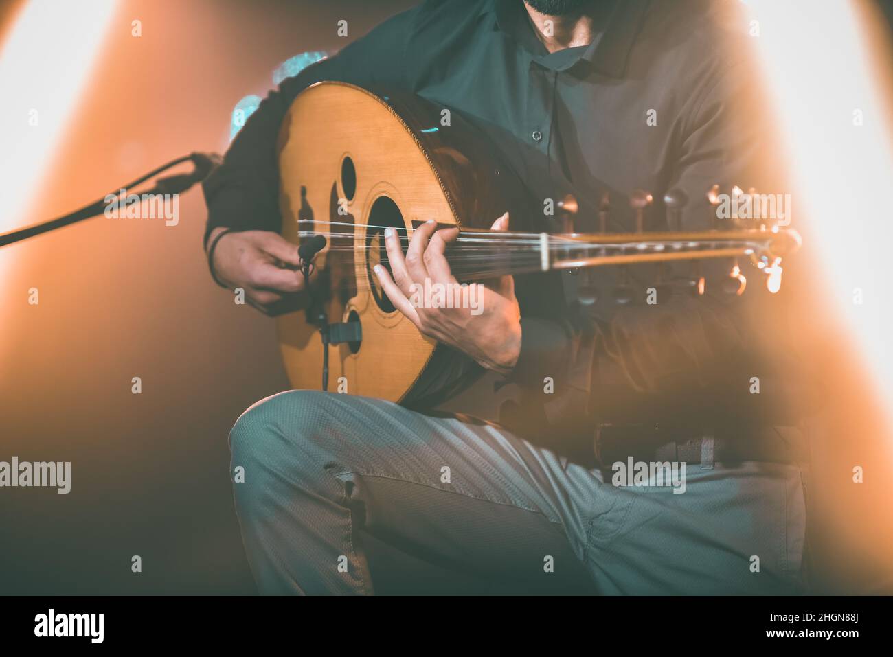 Toned image of musician playing traditional Turkish oud during concert ...