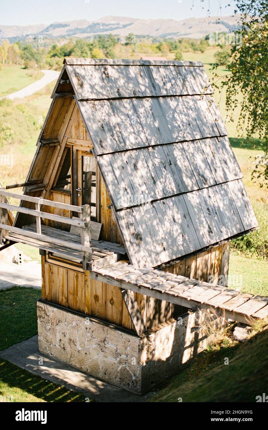 Triangular house with a balcony and a wooden bridge to the hill Stock ...