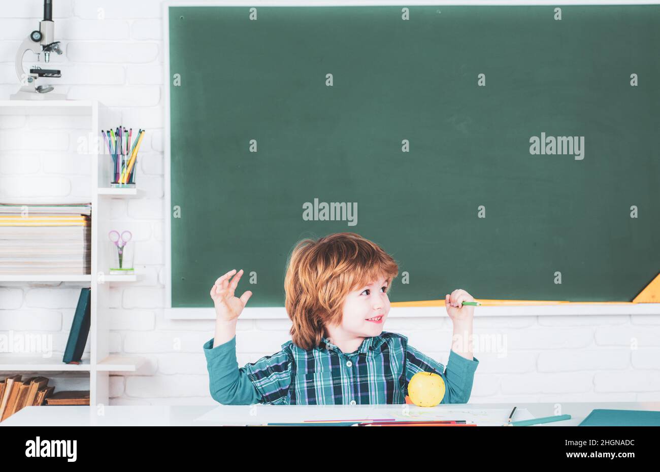 Child near chalkboard in school classroom. Happy school kids at lesson ...