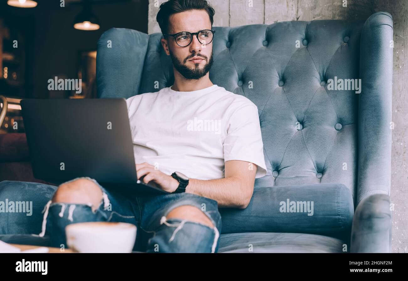 skilled blogger man with netbook thinking indoors Stock Photo - Alamy