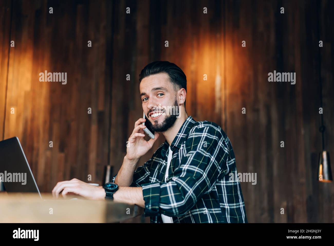 Cheerful man making positive cell conversation during distance job in ...
